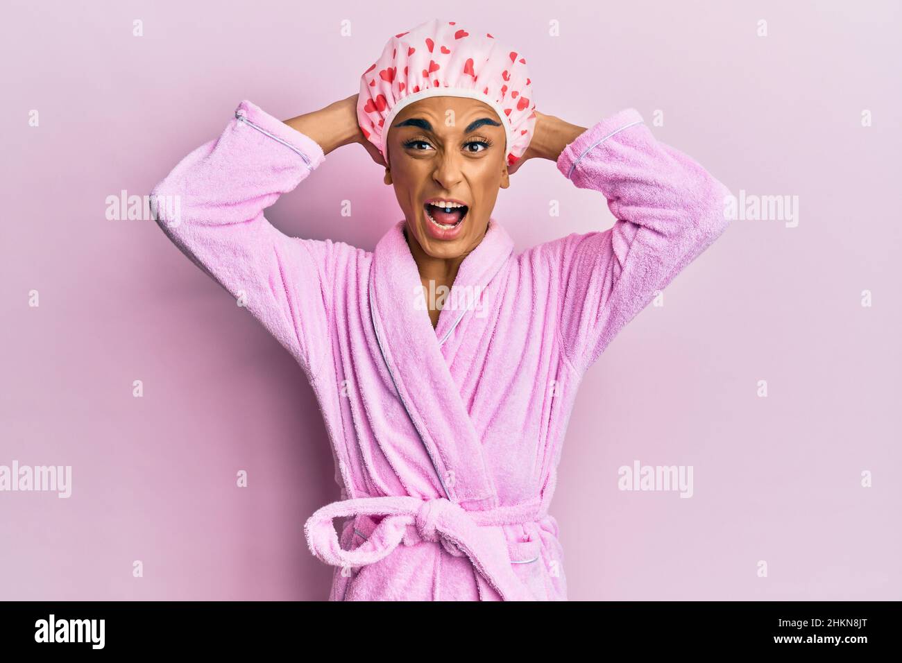 Hispanic man wearing make up wearing shower towel cap and bathrobe ...