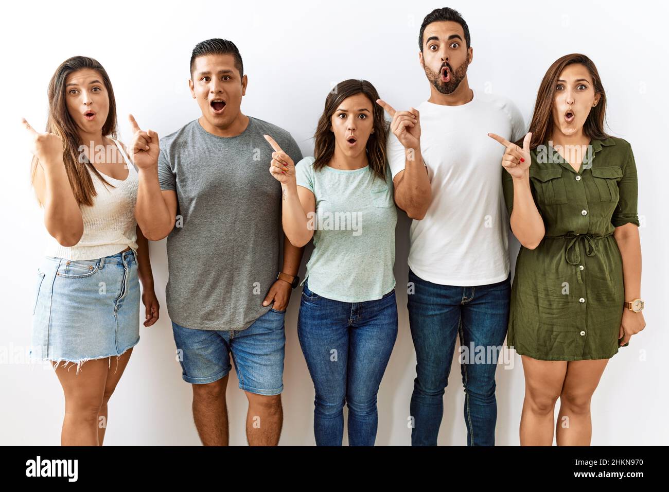 Group of young hispanic friends standing together over isolated ...