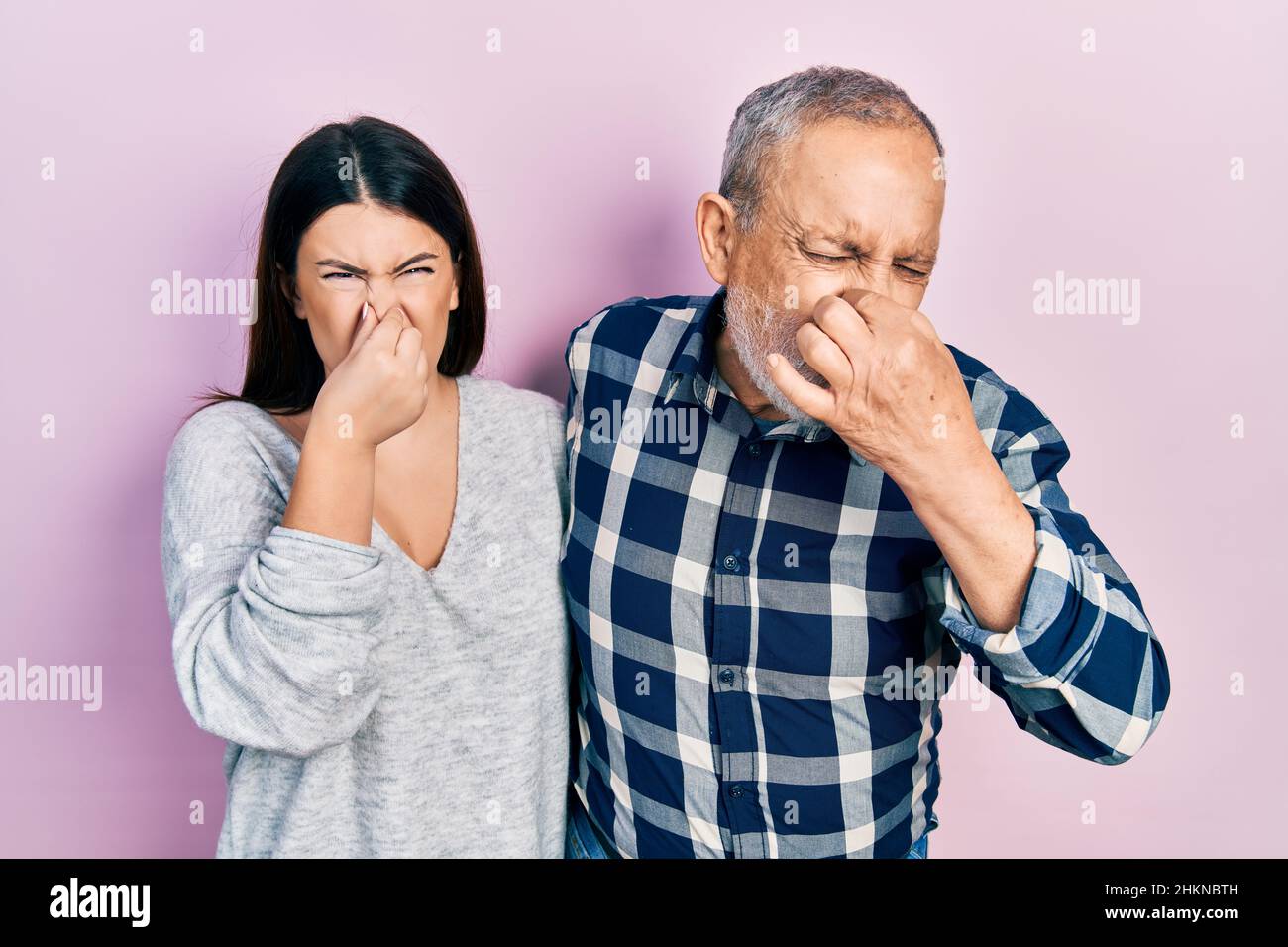 Hispanic father and daughter wearing casual clothes smelling something ...