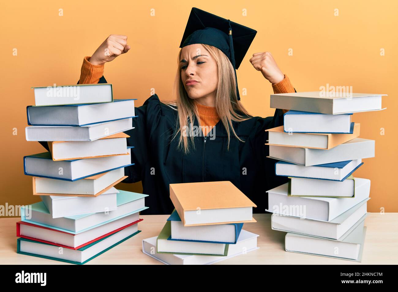 Young caucasian woman wearing graduation ceremony robe sitting on the ...
