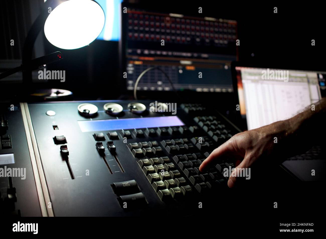 hand about to press button on lighting controls backstage at an event ...