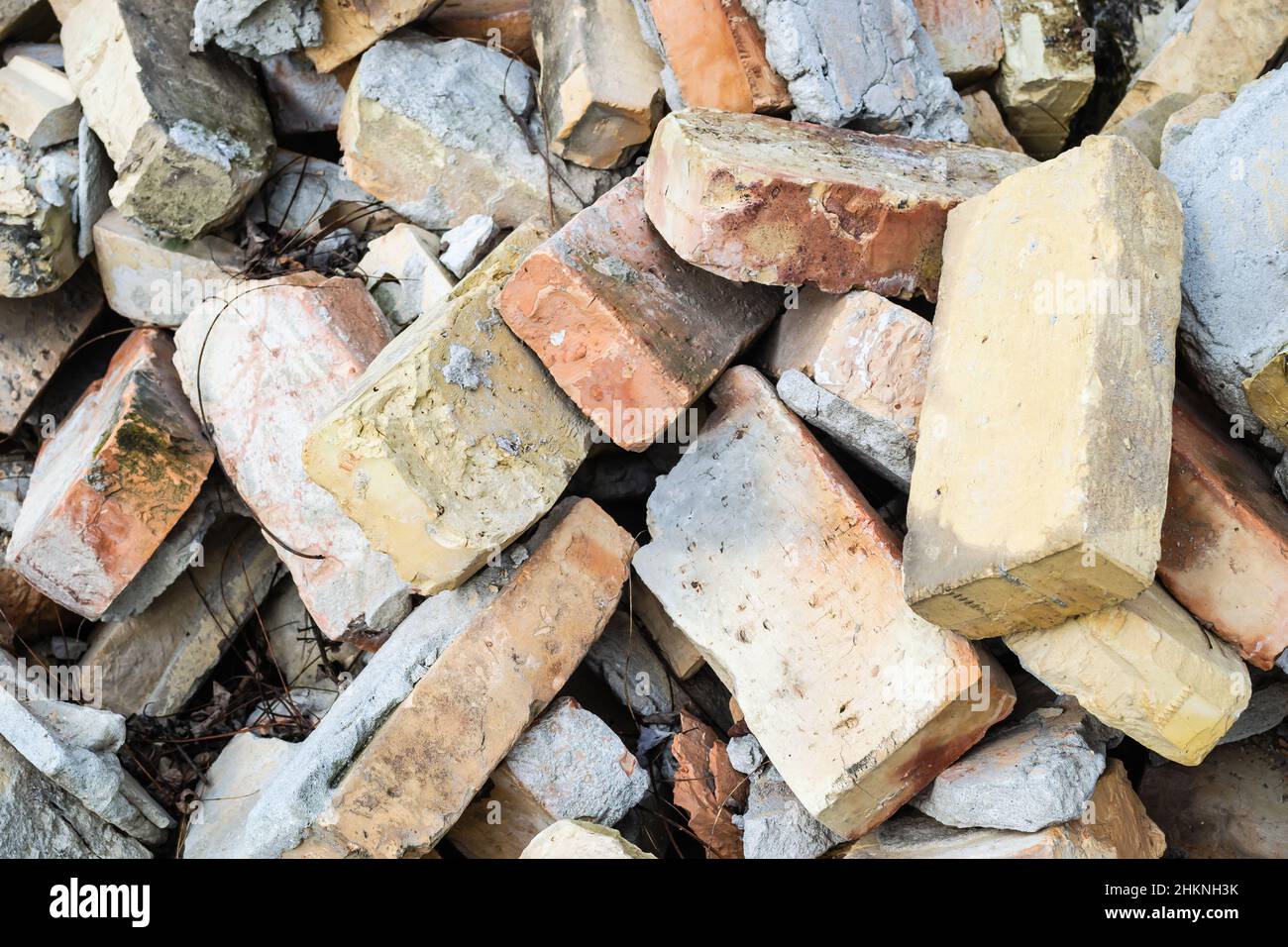 A pile of old used bricks with scratches and cracks from the old wall ...
