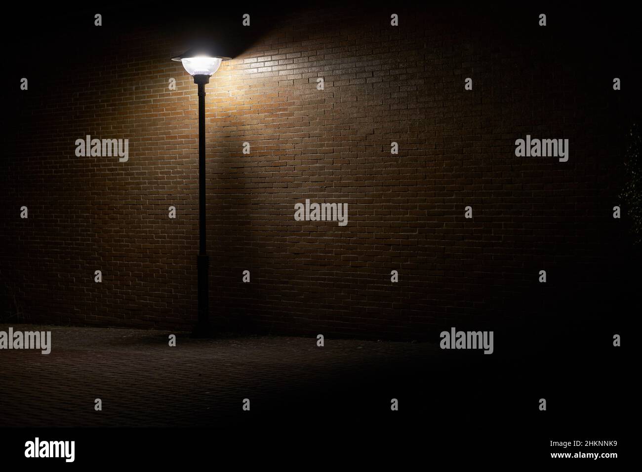 Beautiful and dark lonely street lamp illuminating dark place at night ...