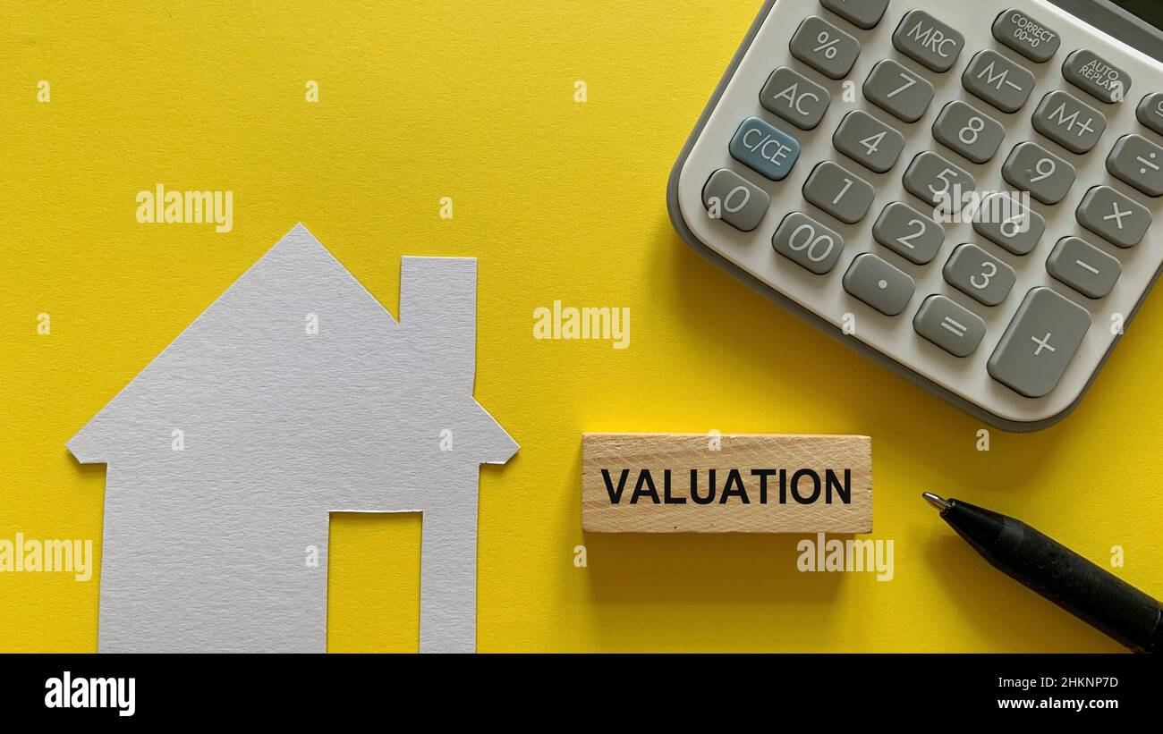 Property valuation text on wooden block with calculator, pen and model ...