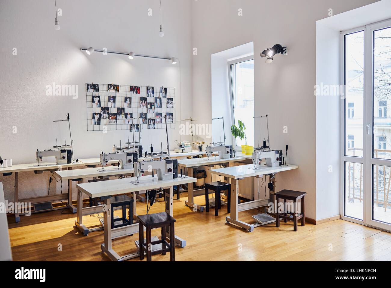 Workplaces with sewing machines and pictures of elegant dresses models ...