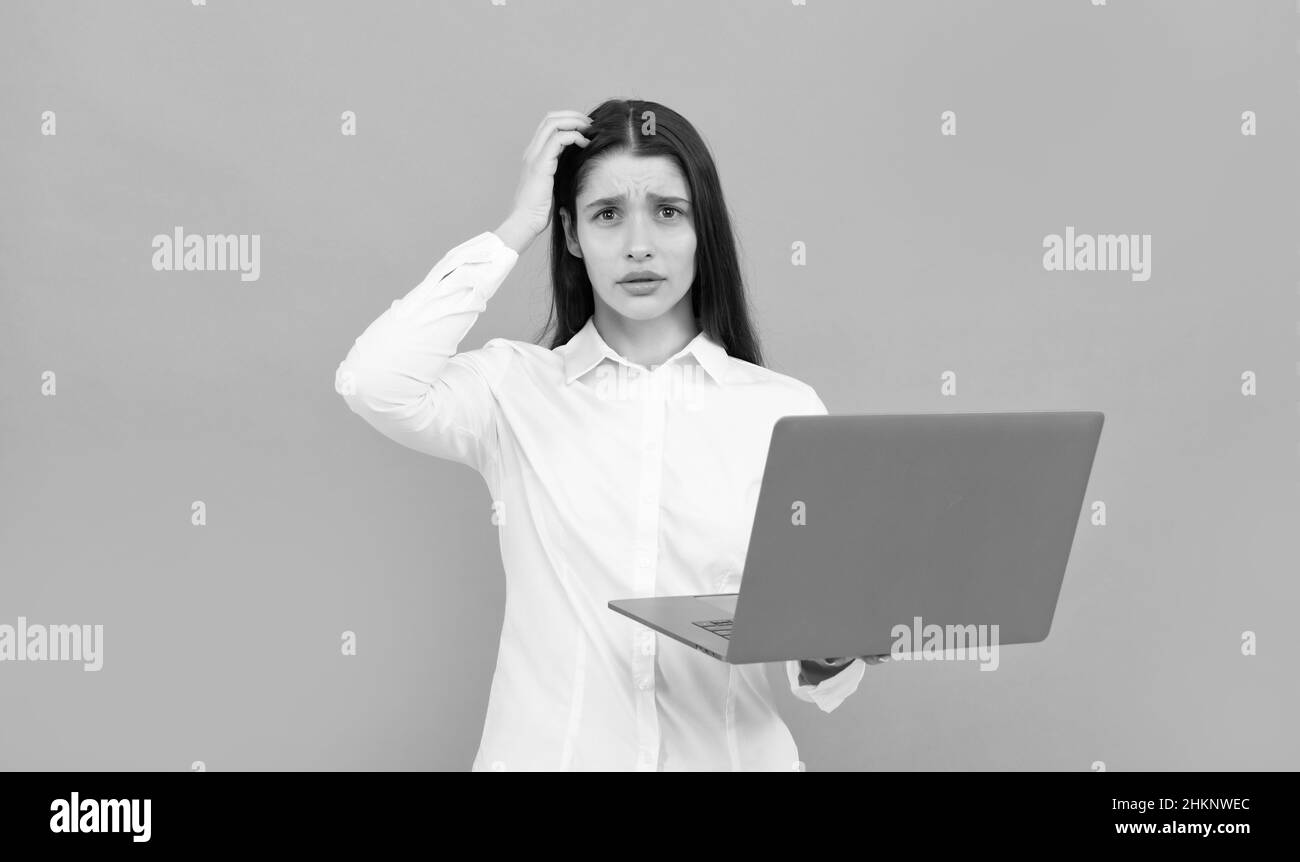 puzzled woman in white shirt hold computer has a lot of work, problem ...