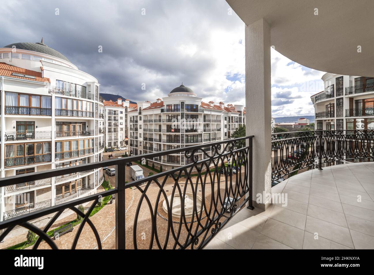 A wide curved balcony of a multi-storey building with metal black ...