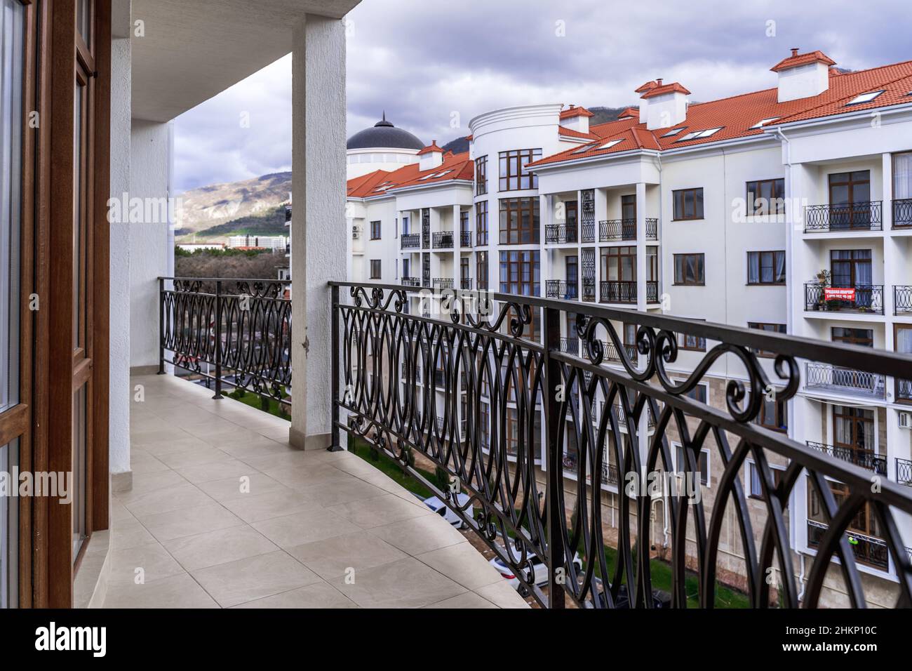 A wide curved balcony of a multi-storey building with metal black ...