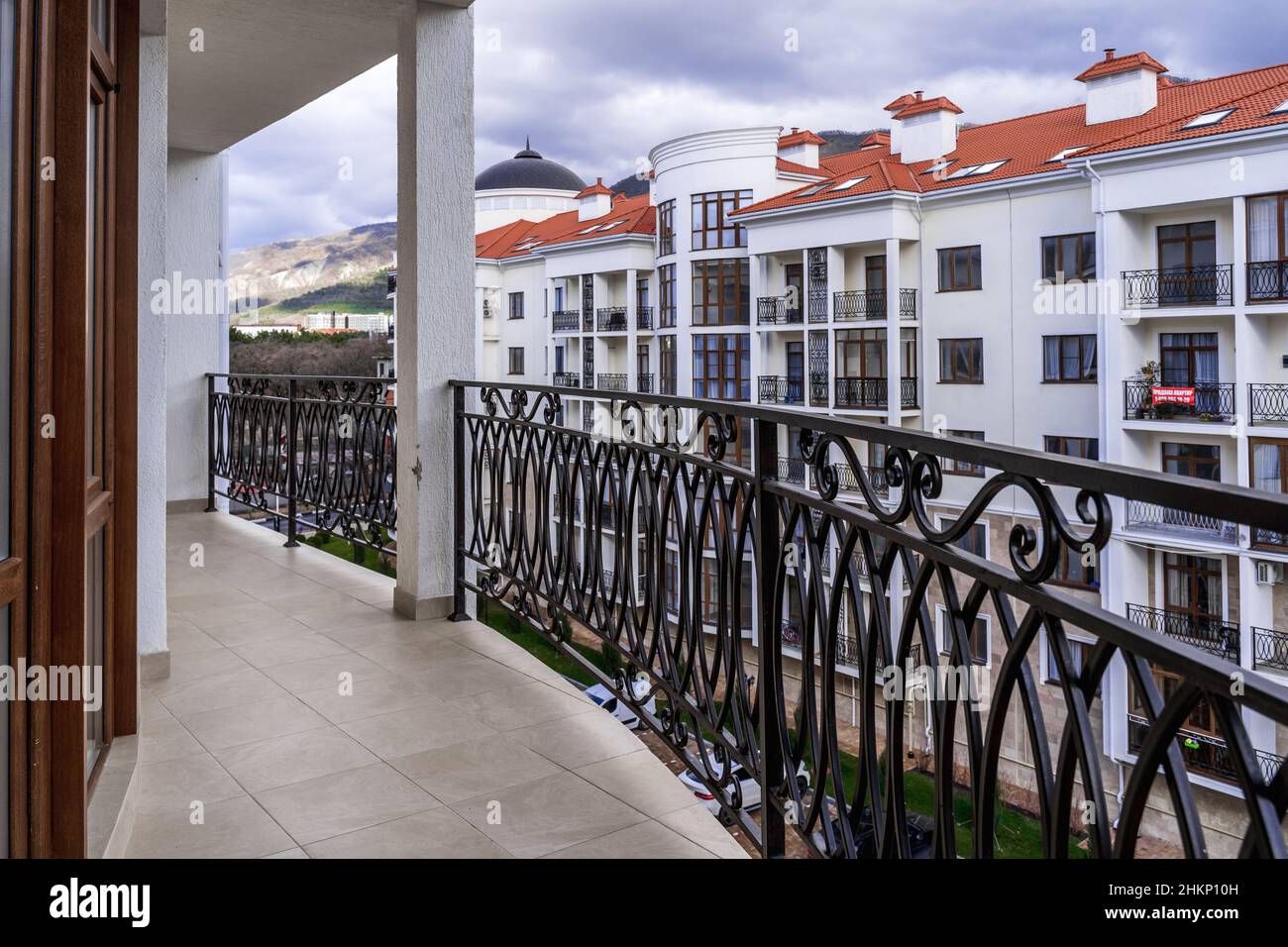 A wide curved balcony of a multi-storey building with metal black ...