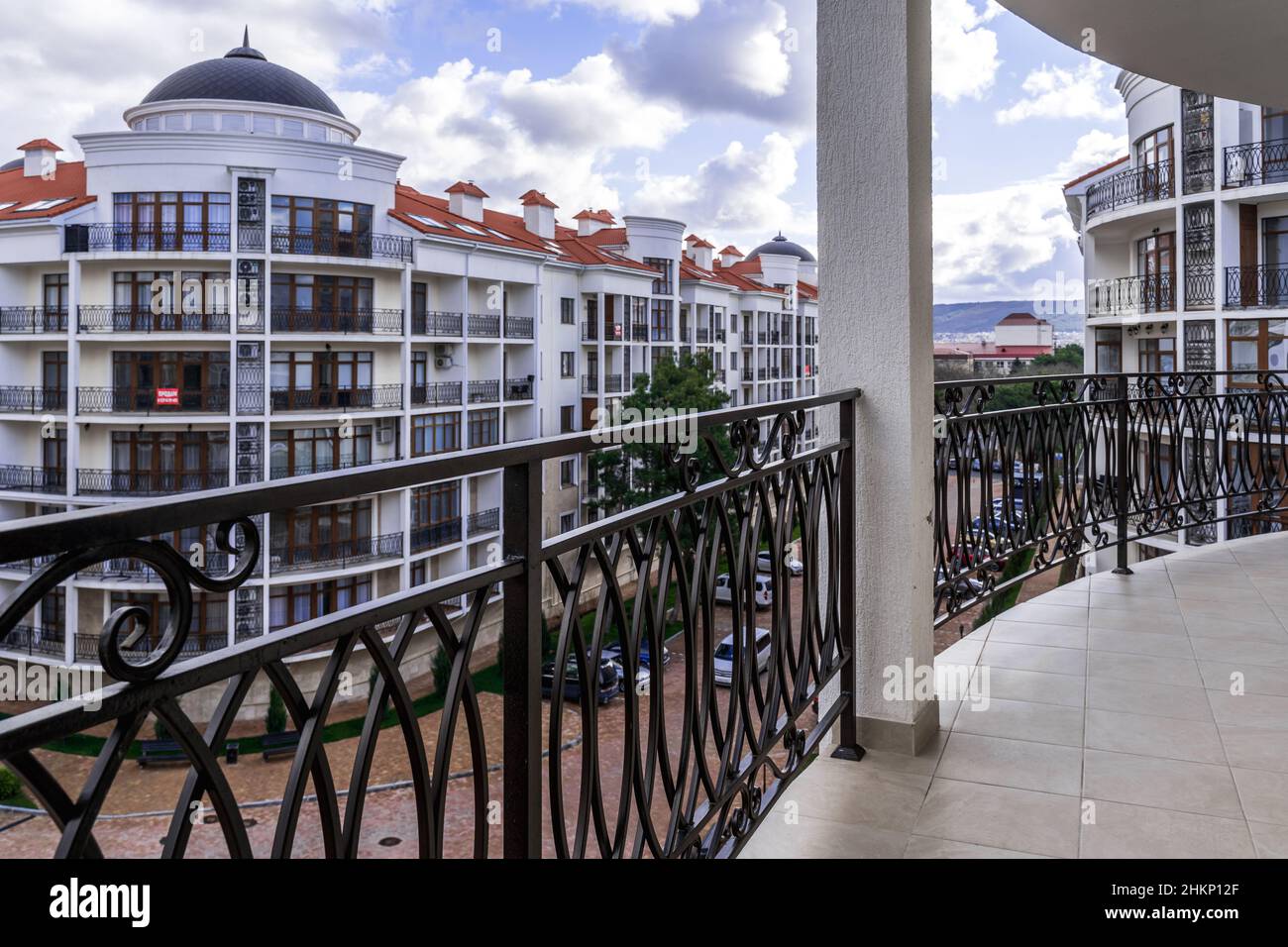 A wide curved balcony of a multi-storey building with metal black ...