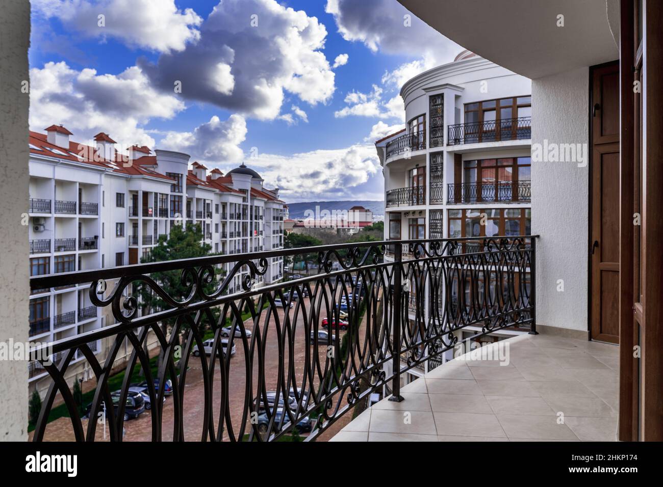A wide curved balcony of a multi-storey building with metal black ...
