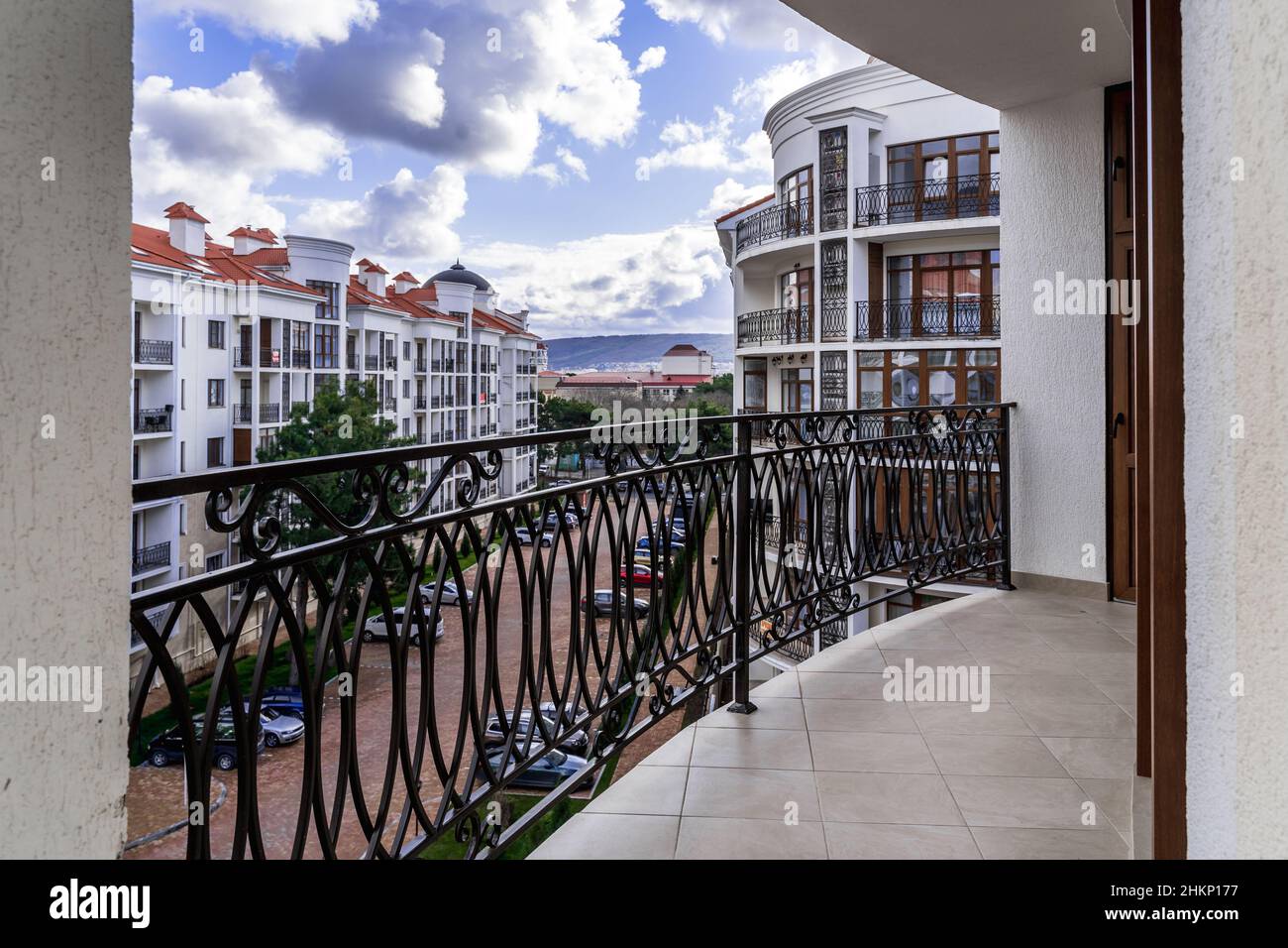 A wide curved balcony of a multi-storey building with metal black ...