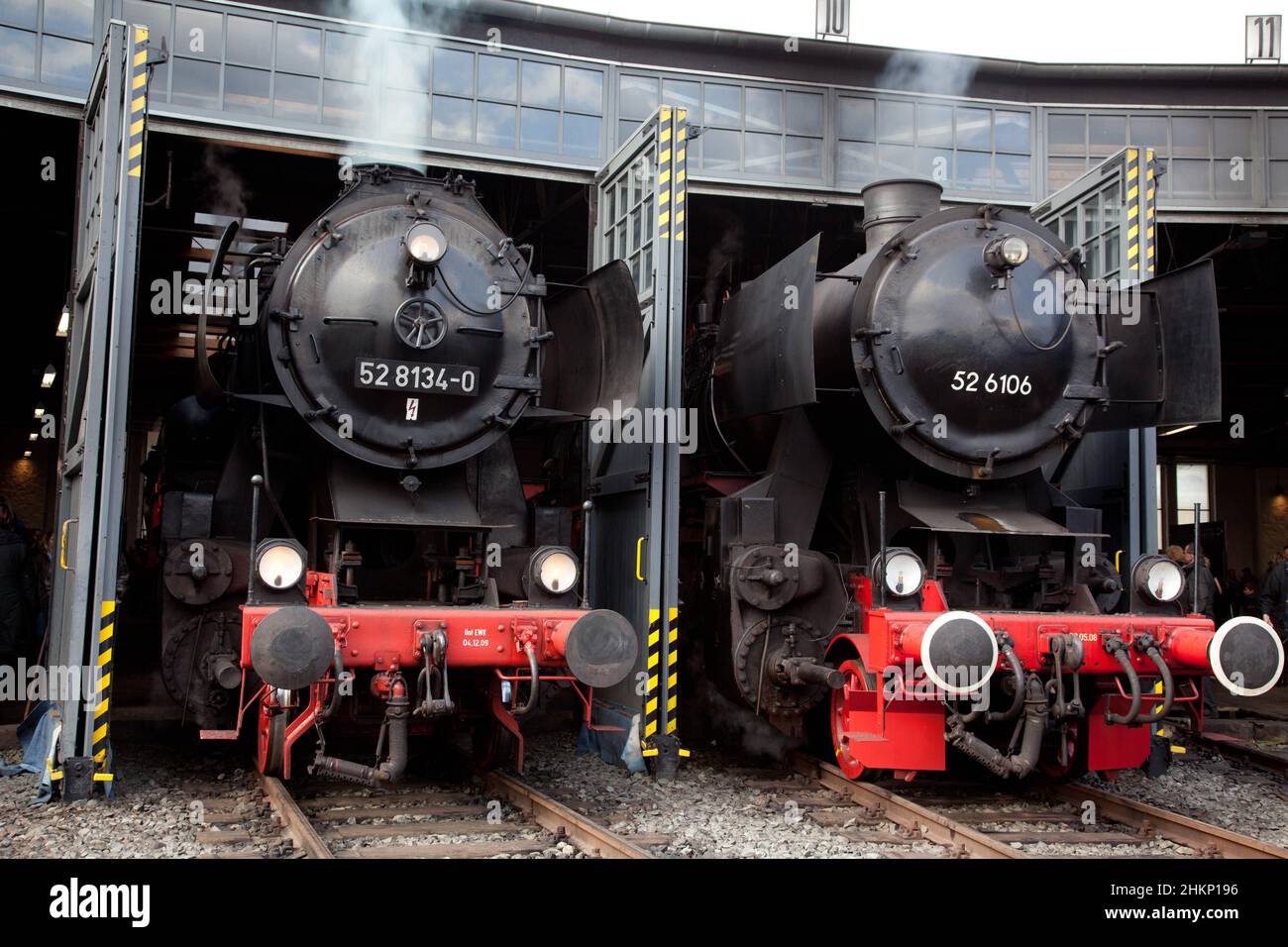 two preserved german steam locomotives at an historic roundhouse depot ...