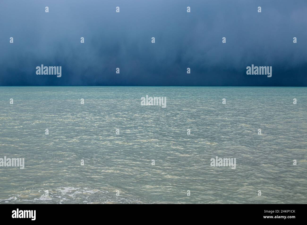 An atmospheric stormy sea with a rich blue color of water and clouds ...