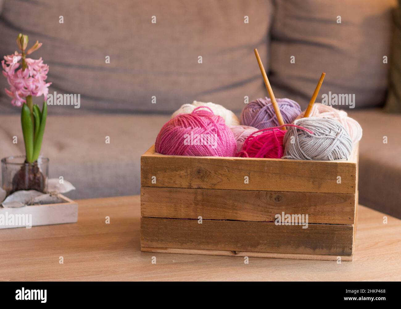 colorful woolen balls in a wooden box with bamboo knitting needles ...