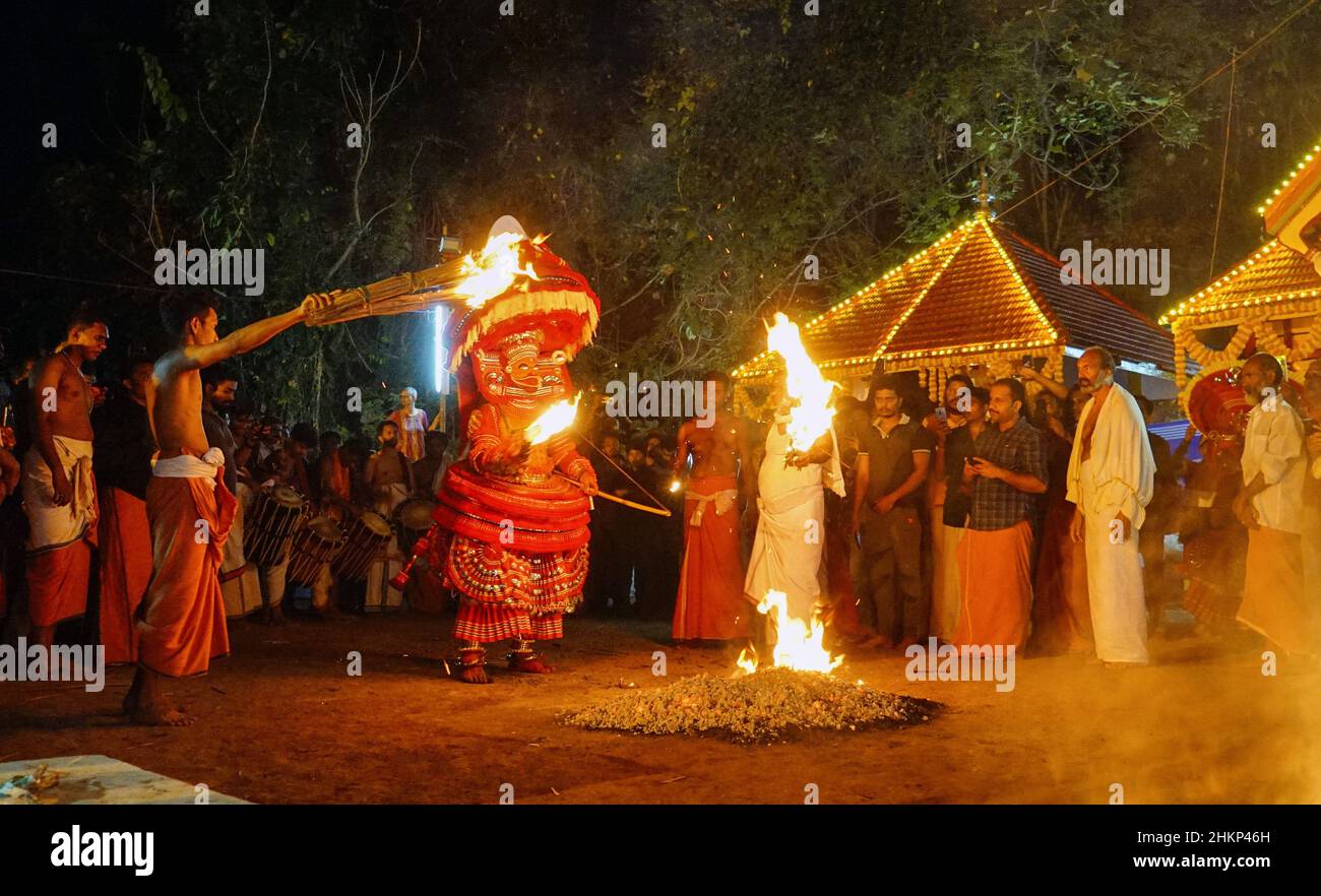 Theyyam performs with fire during the festival in the temple built in ...