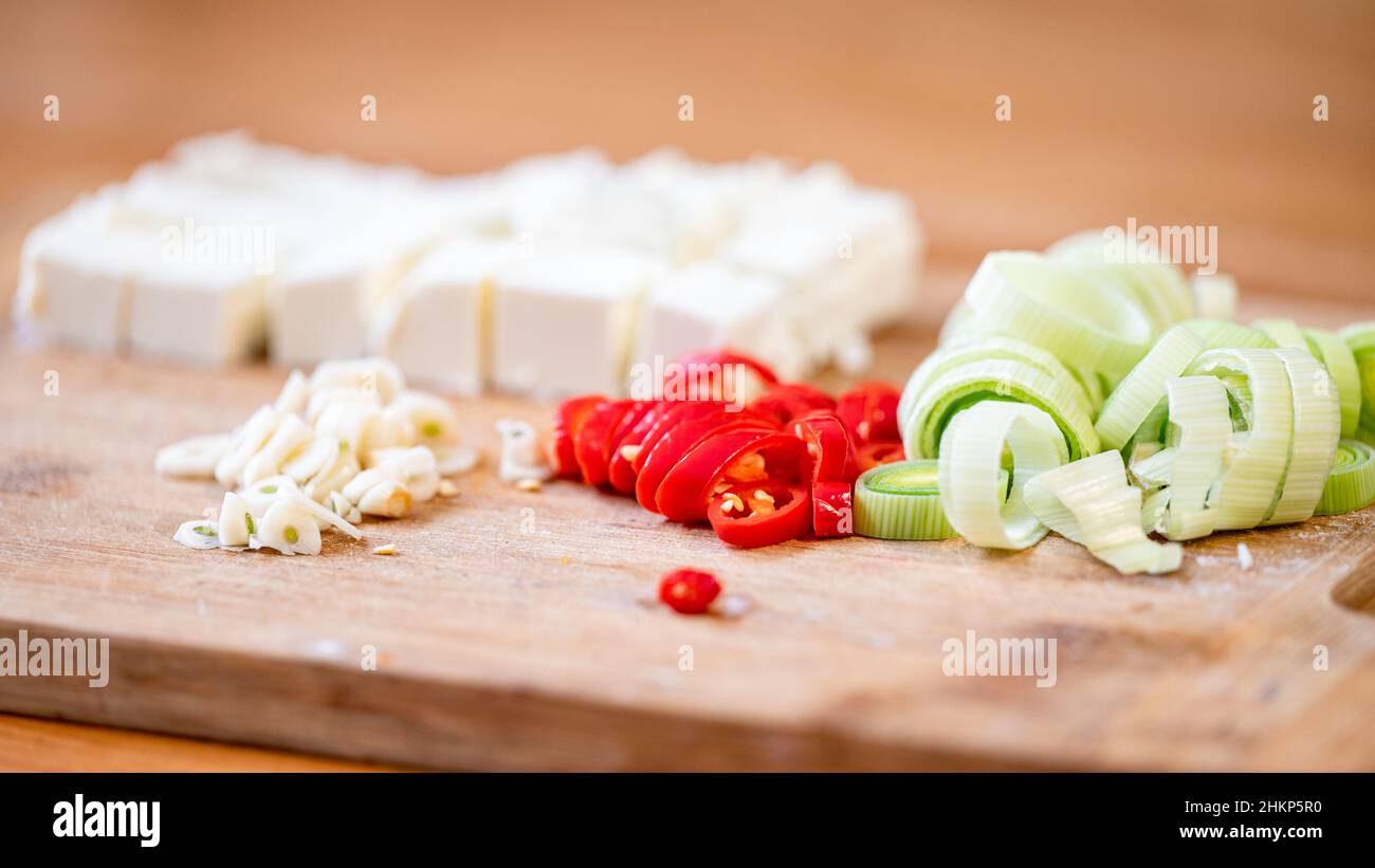 Cheese, leek, chili pepper, and garlic on a chopping board Stock Photo ...