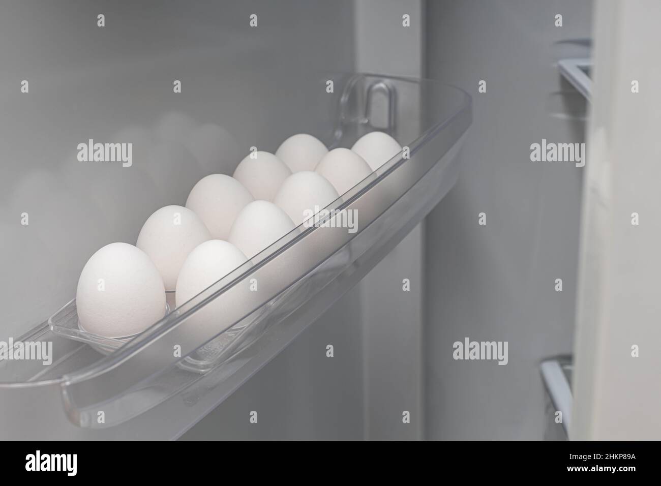 a dozen fresh eggs lie in a special compartment of the refrigerator ...