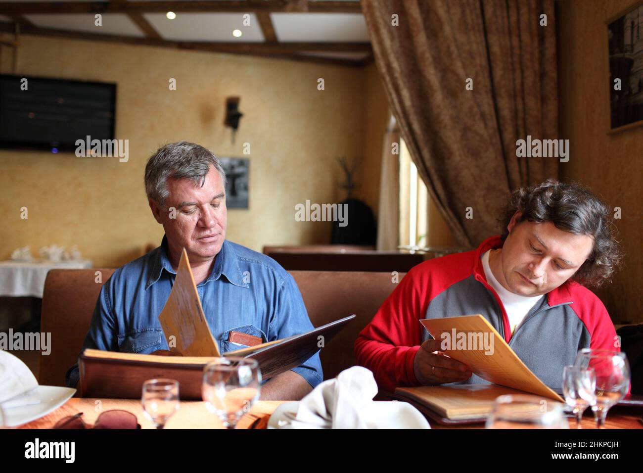 Two men look at menu at the cafe Stock Photo - Alamy