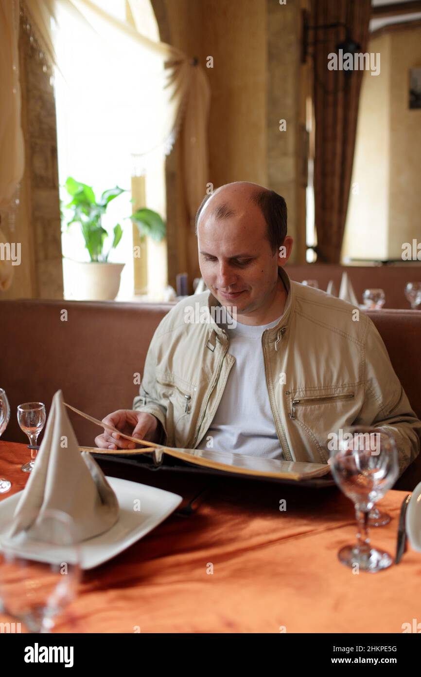 The man reads menu at the restaurant Stock Photo - Alamy