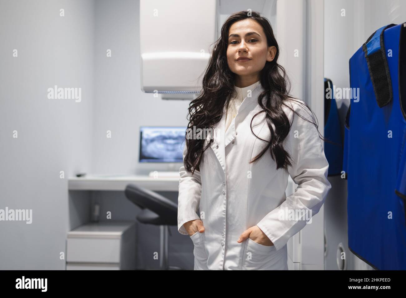 Portrait of female medic in CT scan room. Woman near the tomograph ...