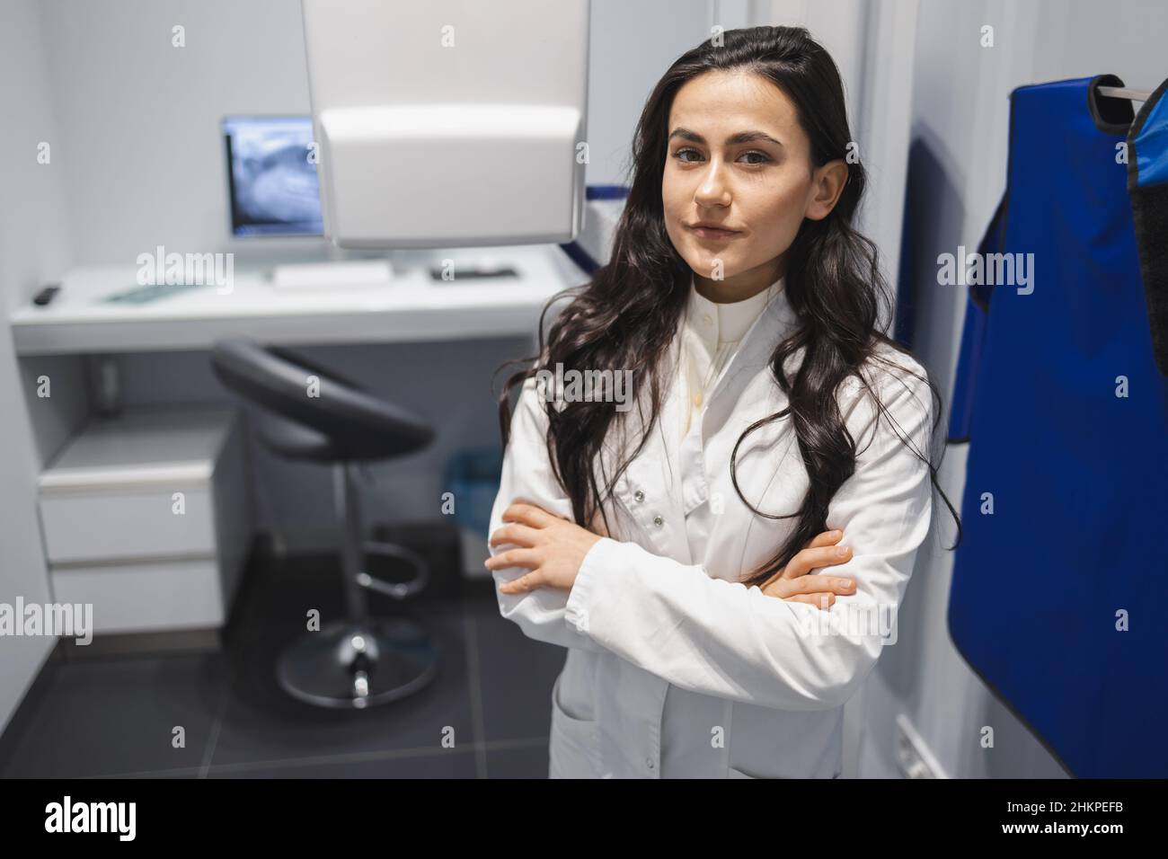 Portrait of serious female medic with arm crossed in CT scan room ...