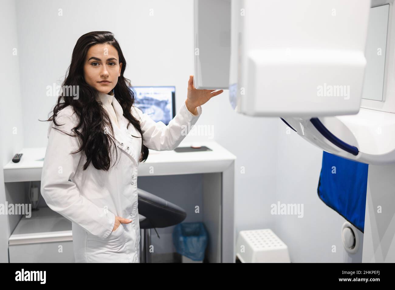 Portrait of serious female medic with arm crossed in CT scan room ...