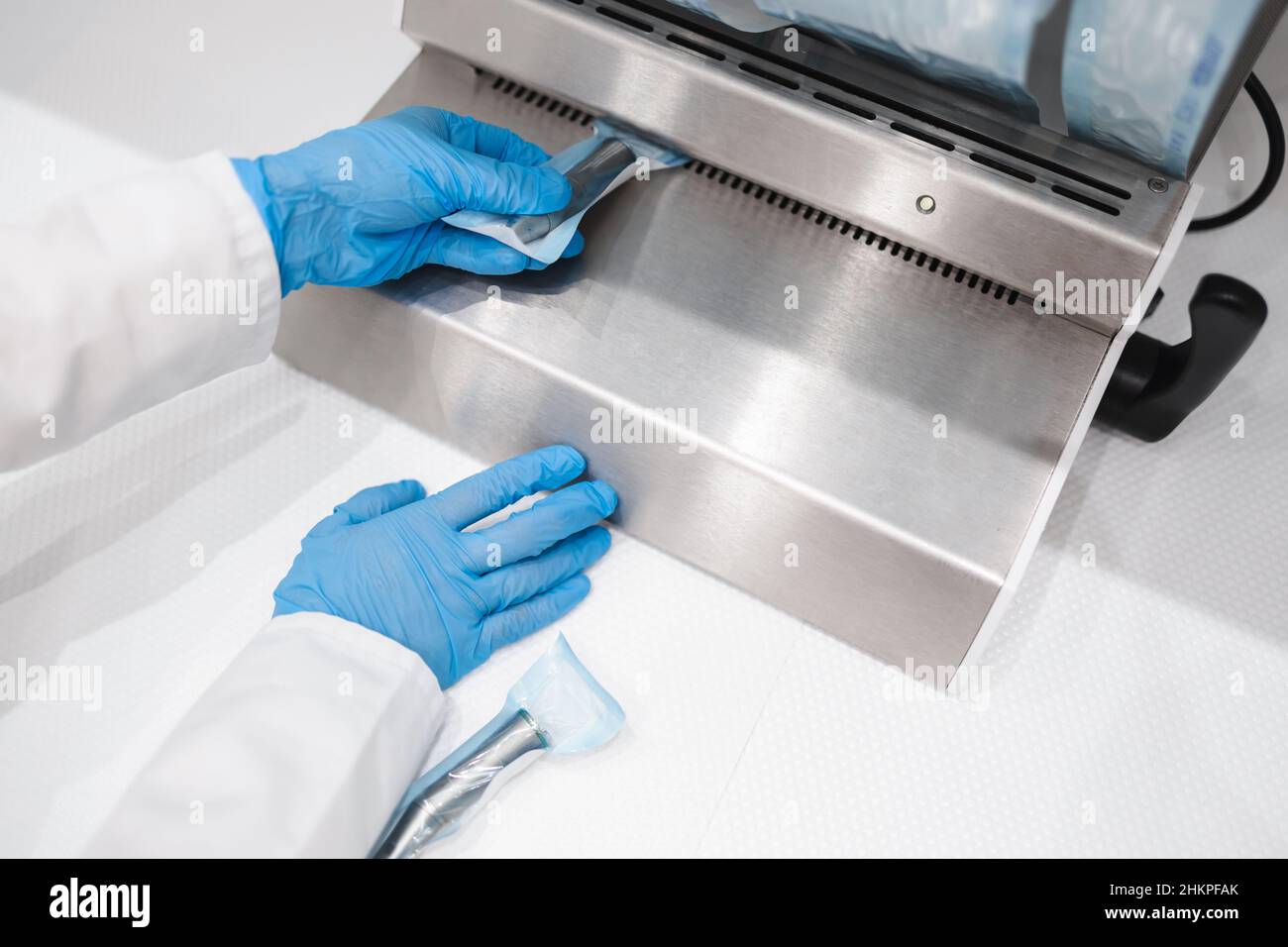 Close up view of dentist assistant's hands in latex gloves holding ...