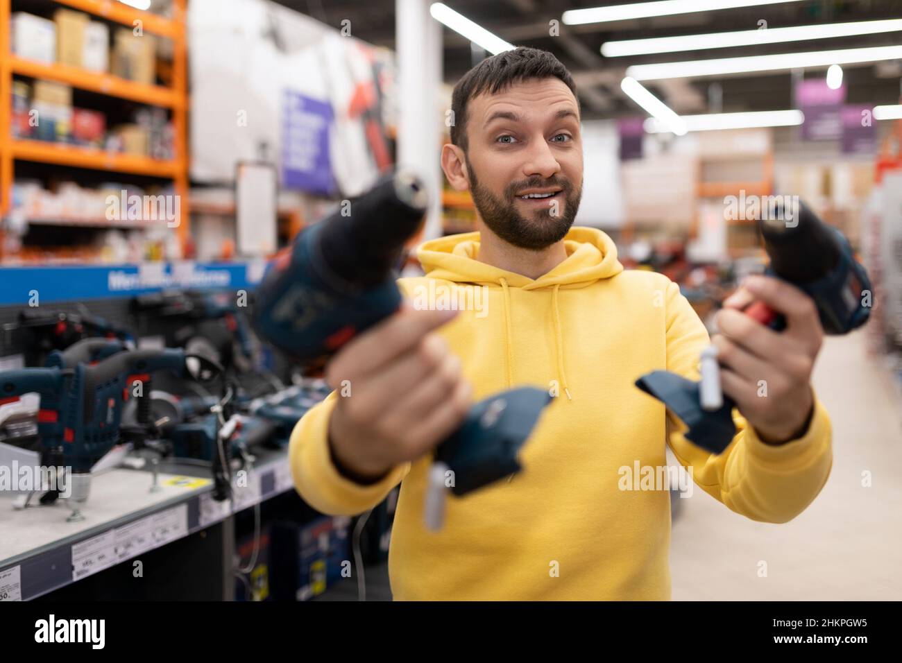 a merchandiser offers a customer a choice of two models of a cordless ...