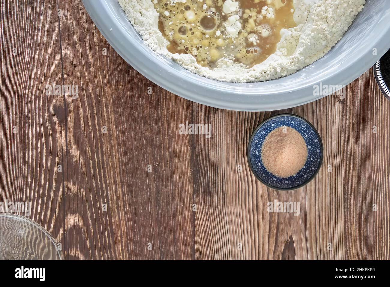 Bowl of dry yeast and flour with liquid mixture for dough making on the ...