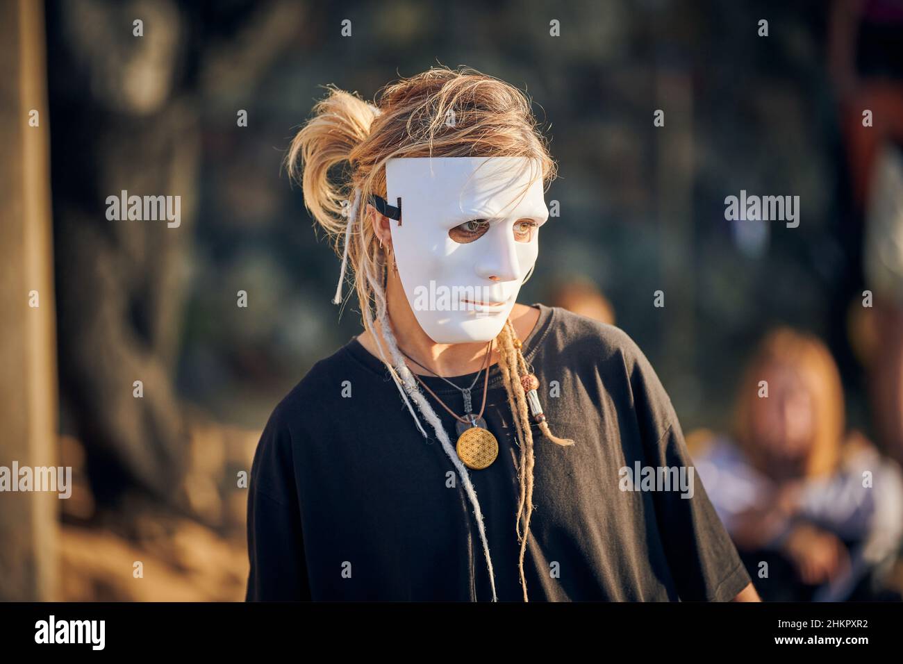 Woman acting in stage persona in theater mask on face, outdoor stage ...