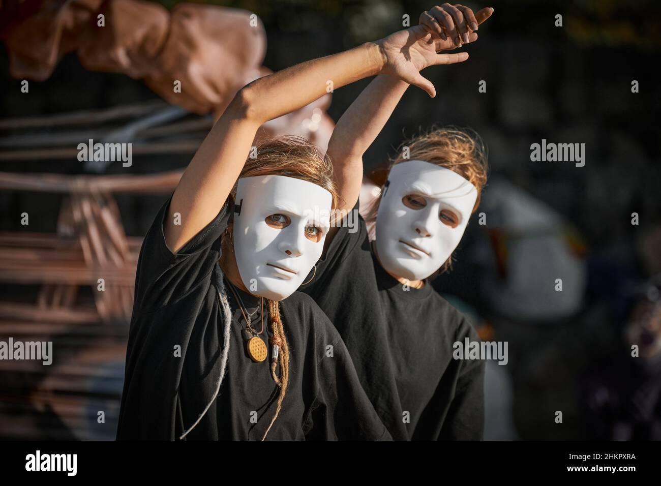 Two girls in white theatre mask dancing on art theatrical festival ...