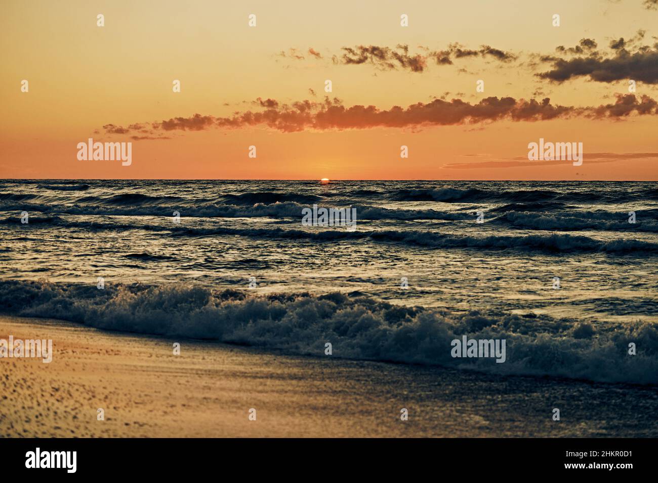 Beautiful sunset over sea waves, half sun below horizon, seacoast view ...