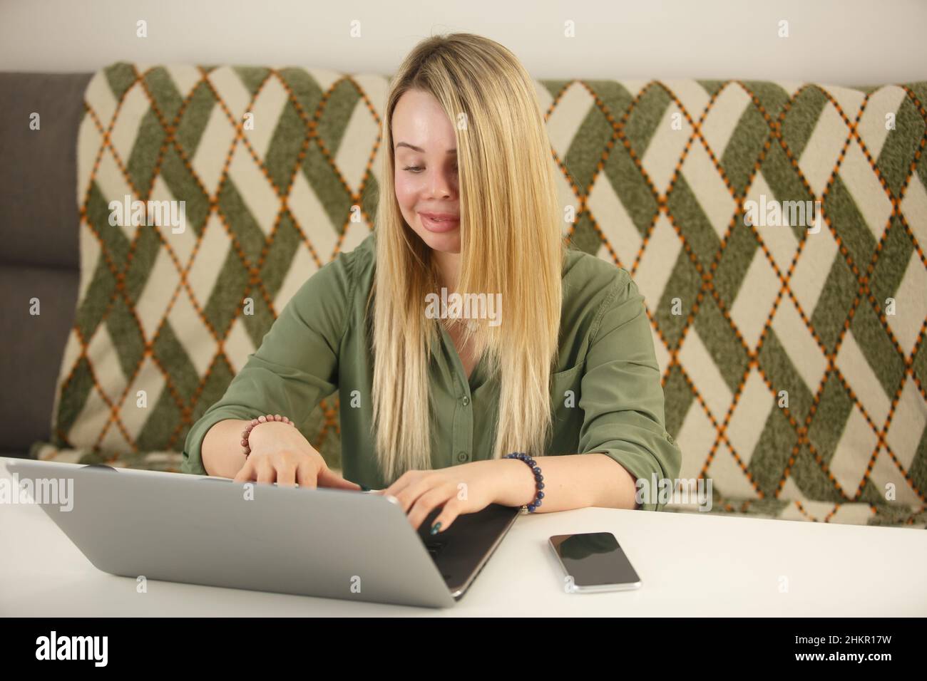 Abuse victim with facial scars working on mobile computer at home ...