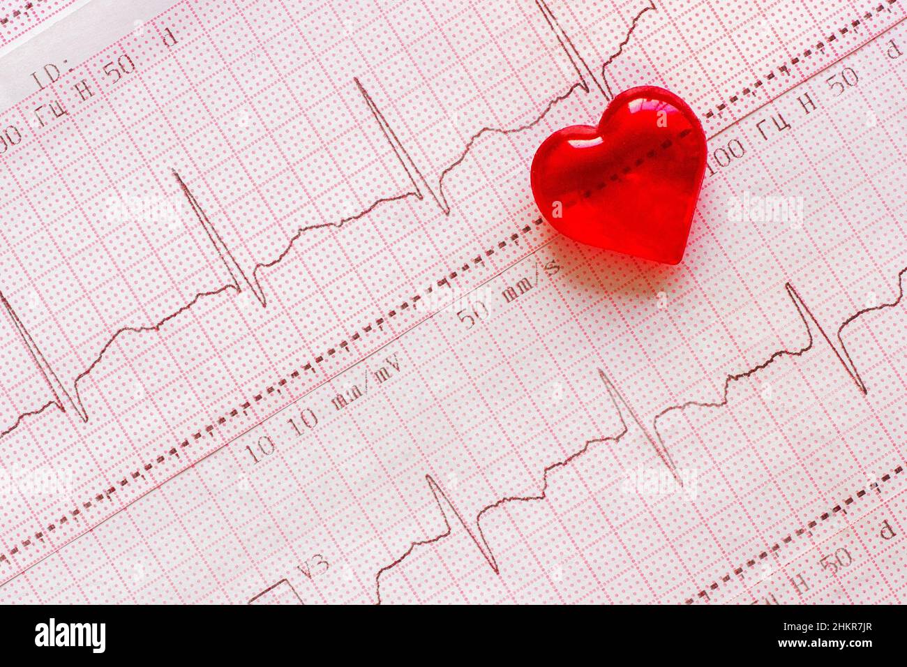 Red plastic heart on the background of the electrocardiogram (ECG). The ...