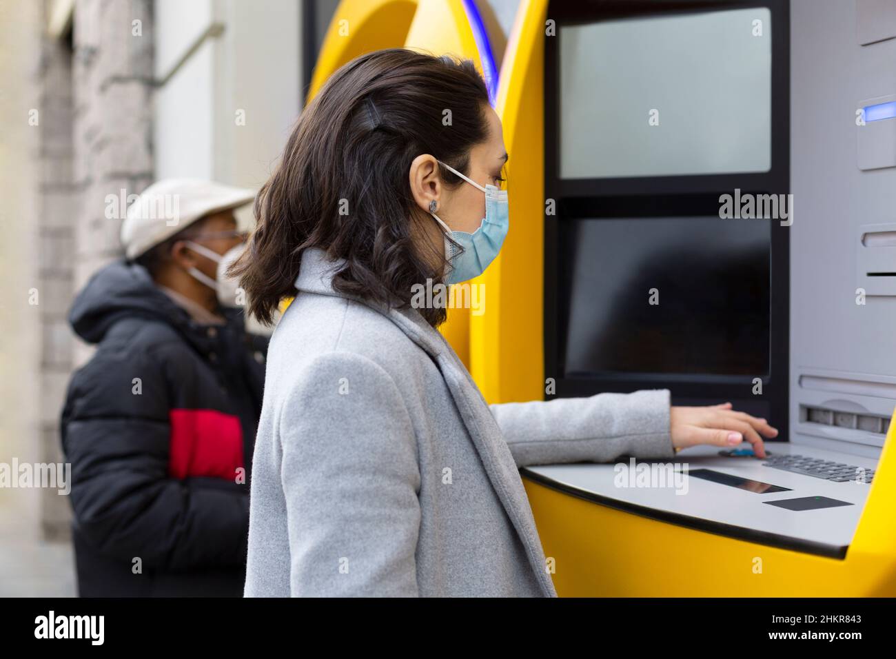 People with face mask outdoors doing banking at an ATM machine Stock ...
