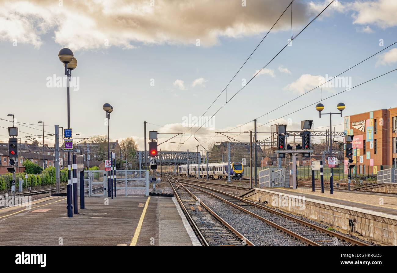 The end of a railway platform where tracks disappear into the distance ...