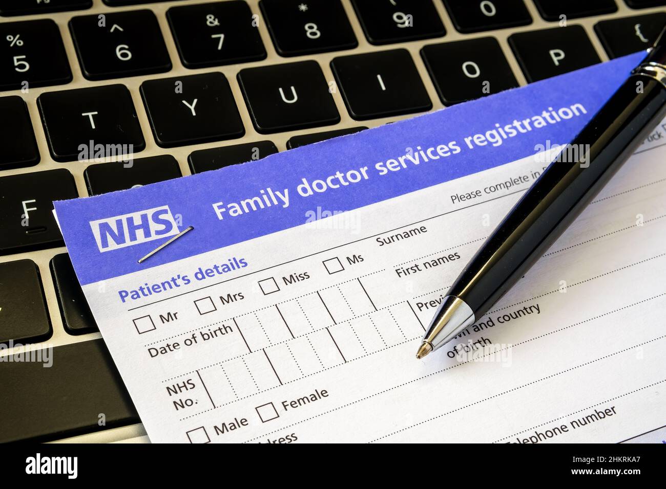 UK NHS Family doctor services registration form placed on keyboard ...