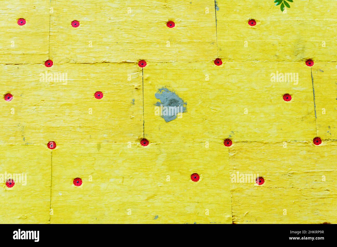 The wall of the house is finished with yellow insulation plates ...