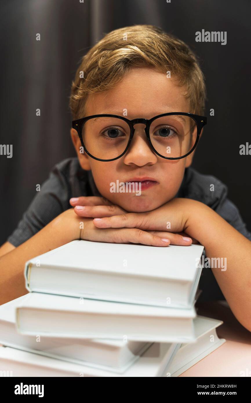 a boy with glasses and a stack of books, back to school, study fatigue ...
