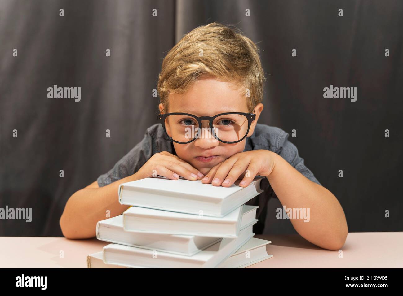 a boy with glasses and a stack of books, back to school, study fatigue ...