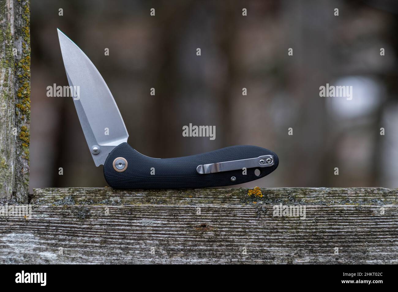Pocket folding knife with black handle. Knife in a curved position on a ...