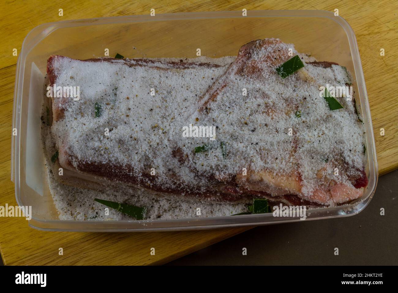 Close up of Dry salt cure on Pork belly joint at start of curing ...