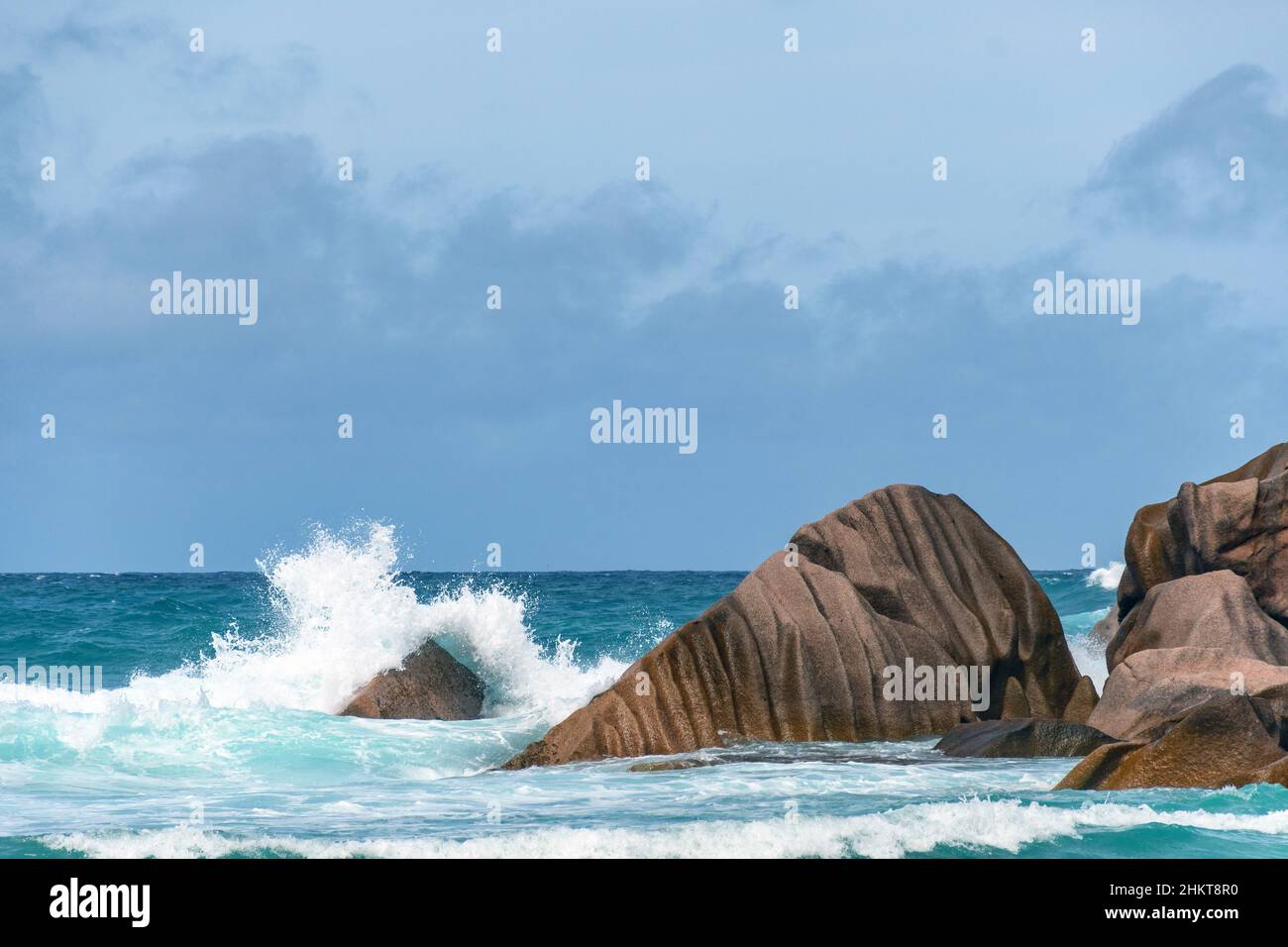 Tropical scenery with rough sea waves splashing against rock formation ...