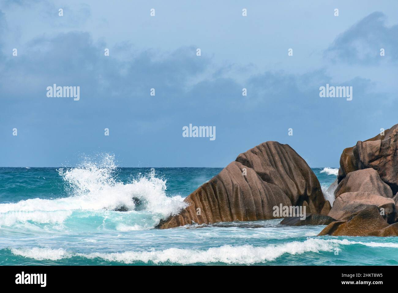 Tropical scenery with rough sea waves splashing against rock formation ...