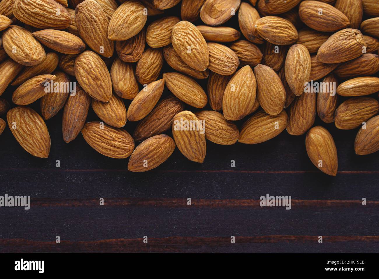 Close up almonds on dark wooden table. Organic health protein ...