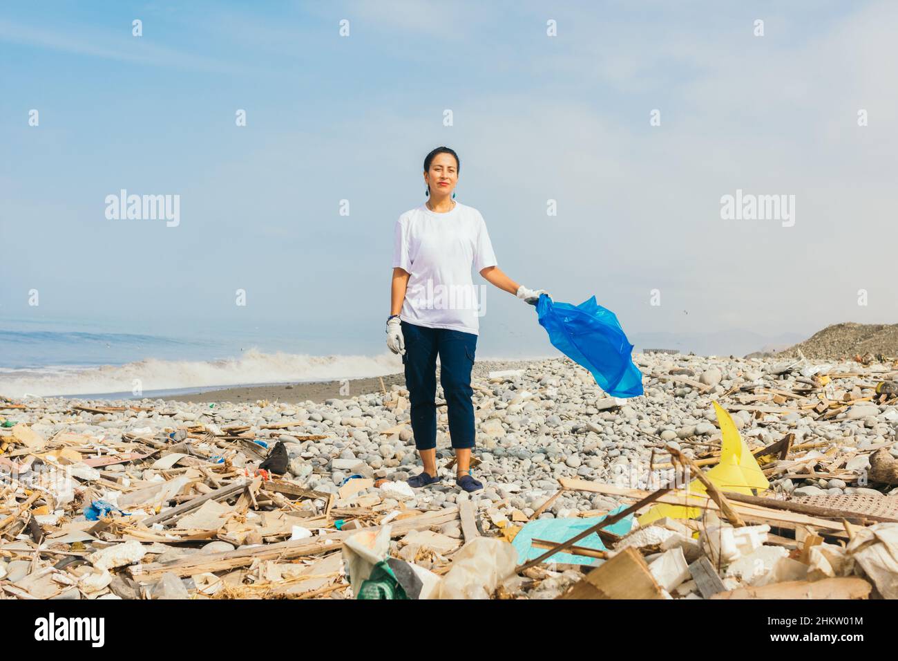 Young volunteer on beach full of garbage Stock Photo - Alamy