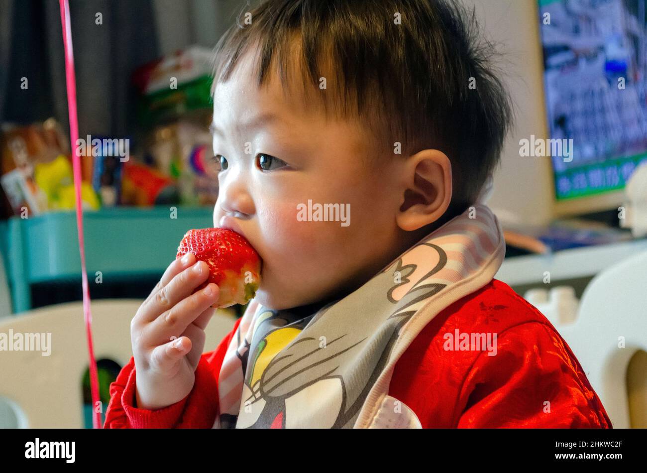 A baby Chinese boy eating a Strawberry, Hong Kong, China Stock Photo ...