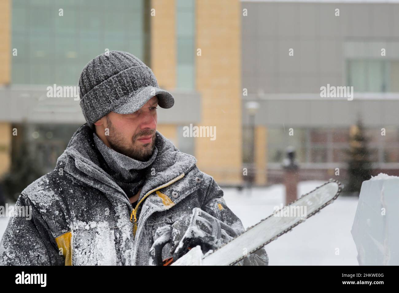 The sculptor cuts ice contours from ice with a chainsaw for Christmas ...