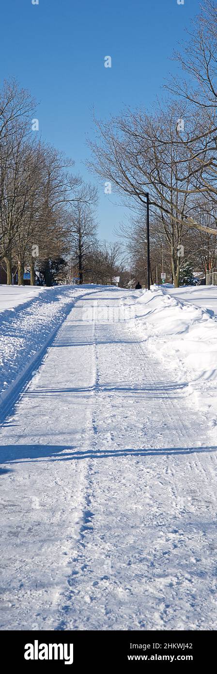 Panoramic vertical photo of the footpath covered with deep white snow ...